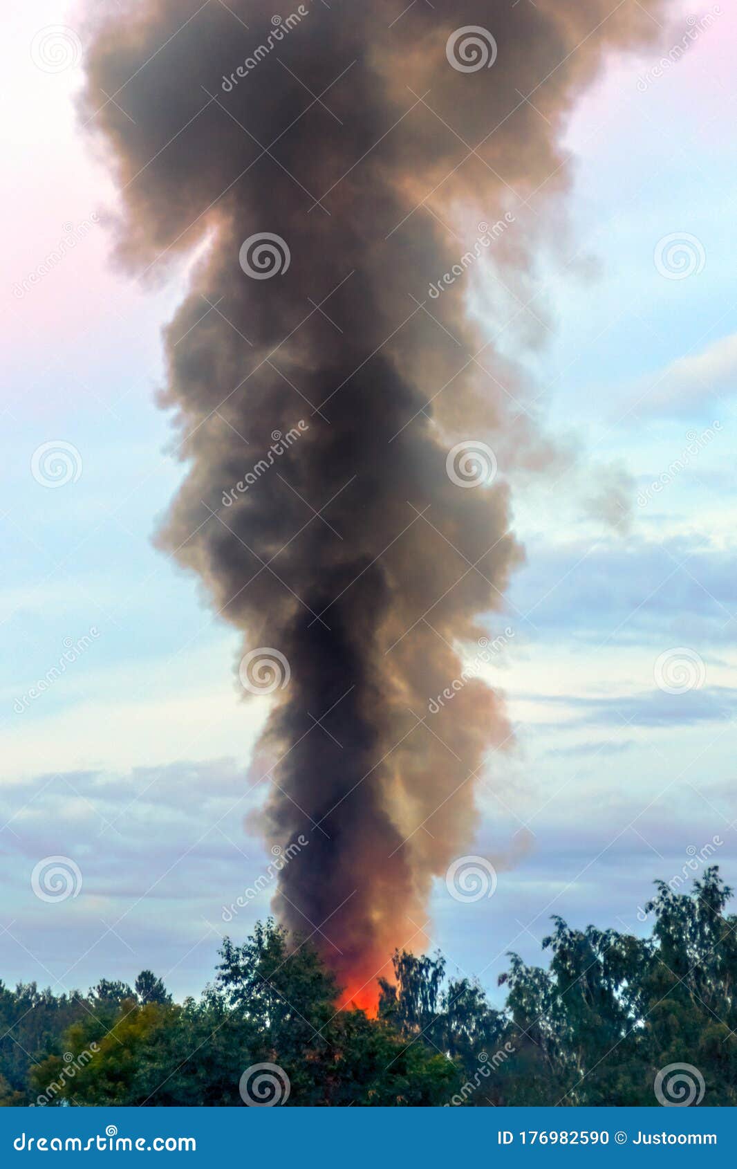 The Building Burns with Fire and Black Smoke Against the Evening Sky ...