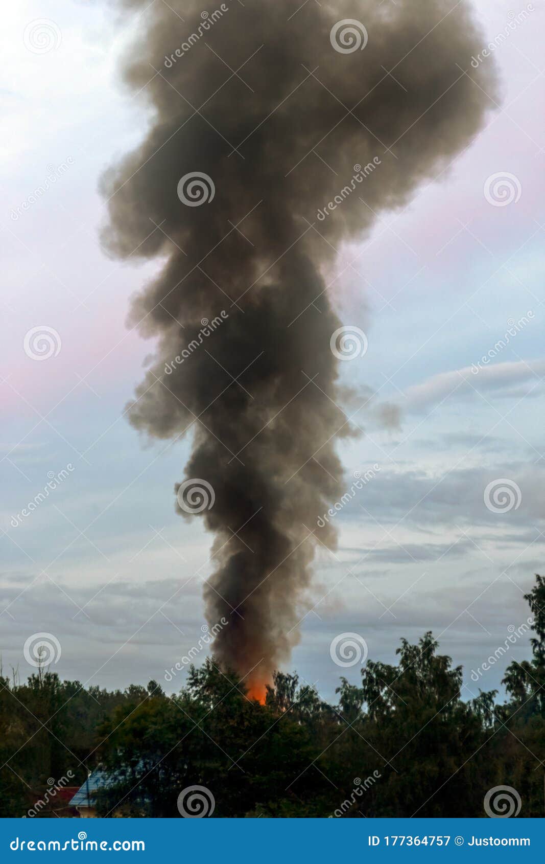 The Building Burns with Fire and Black Smoke Against the Evening Sky ...