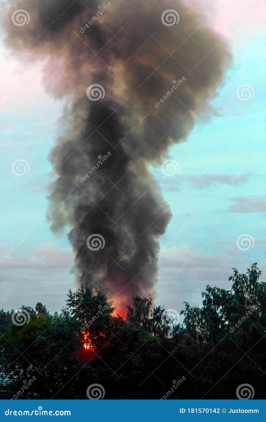 The Building Burns With Fire And Black Smoke Against The Evening Sky ...