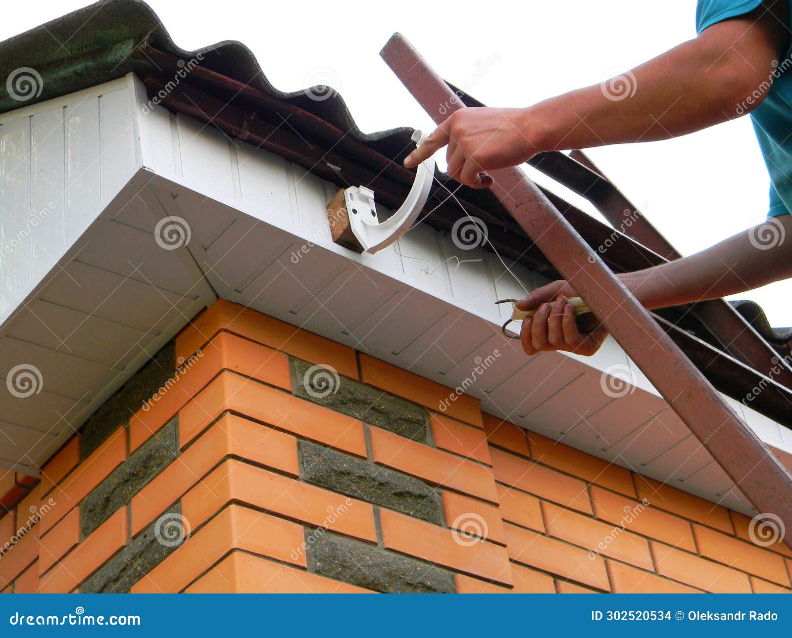 A Building Contractor is Installing Rain Gutter System, Fitting ...