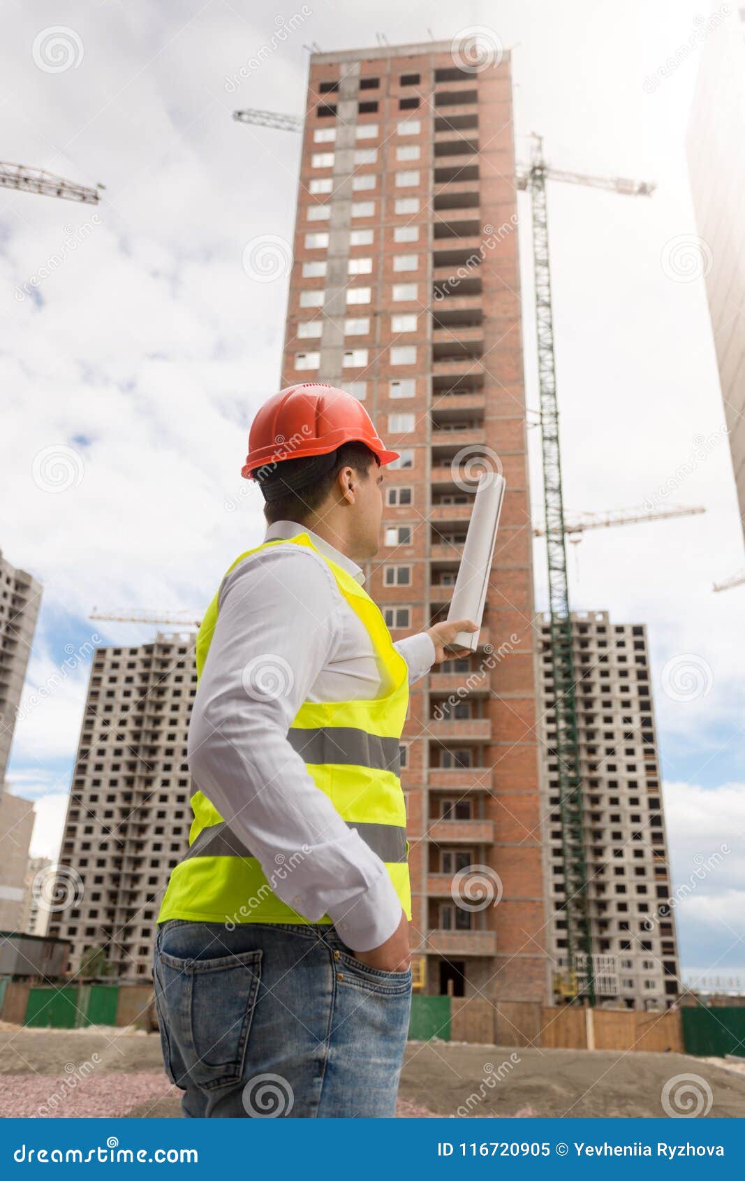 Male Building Engineer in Hardhat Pointing at Construction Site with ...
