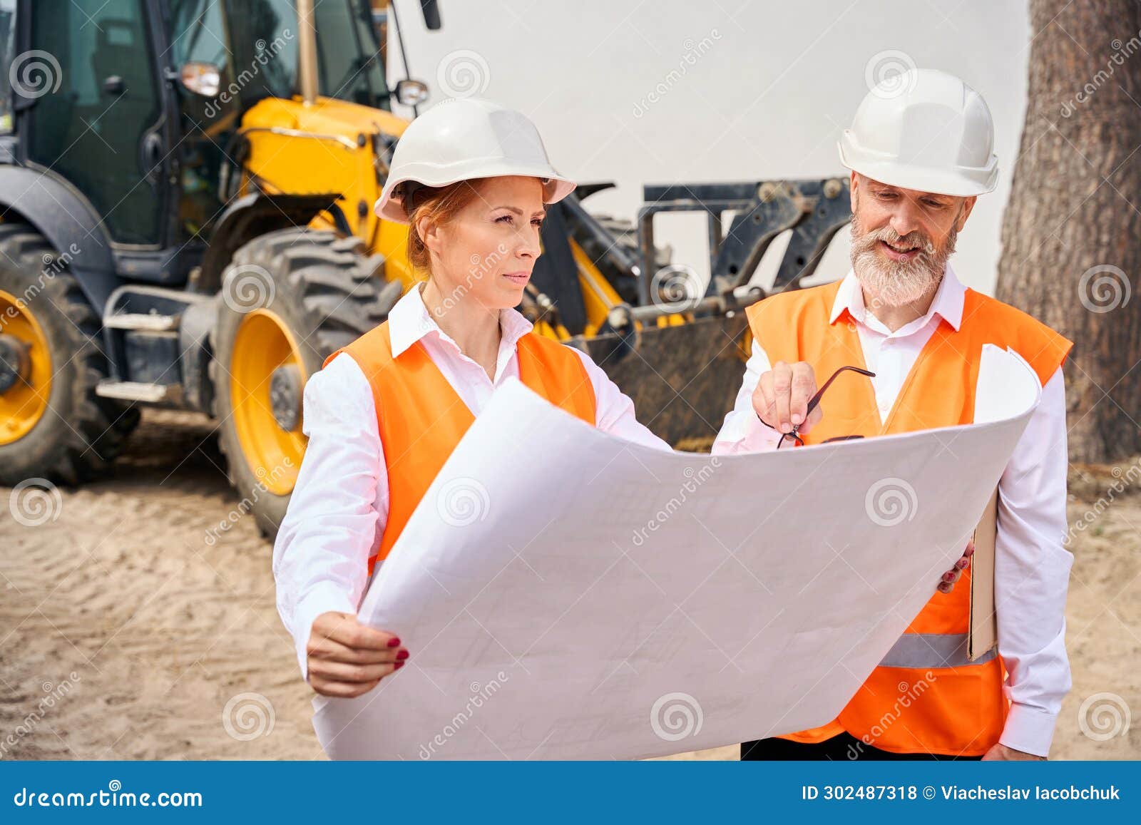Building Inspector and Contractor Using Blueprints during Inspection ...