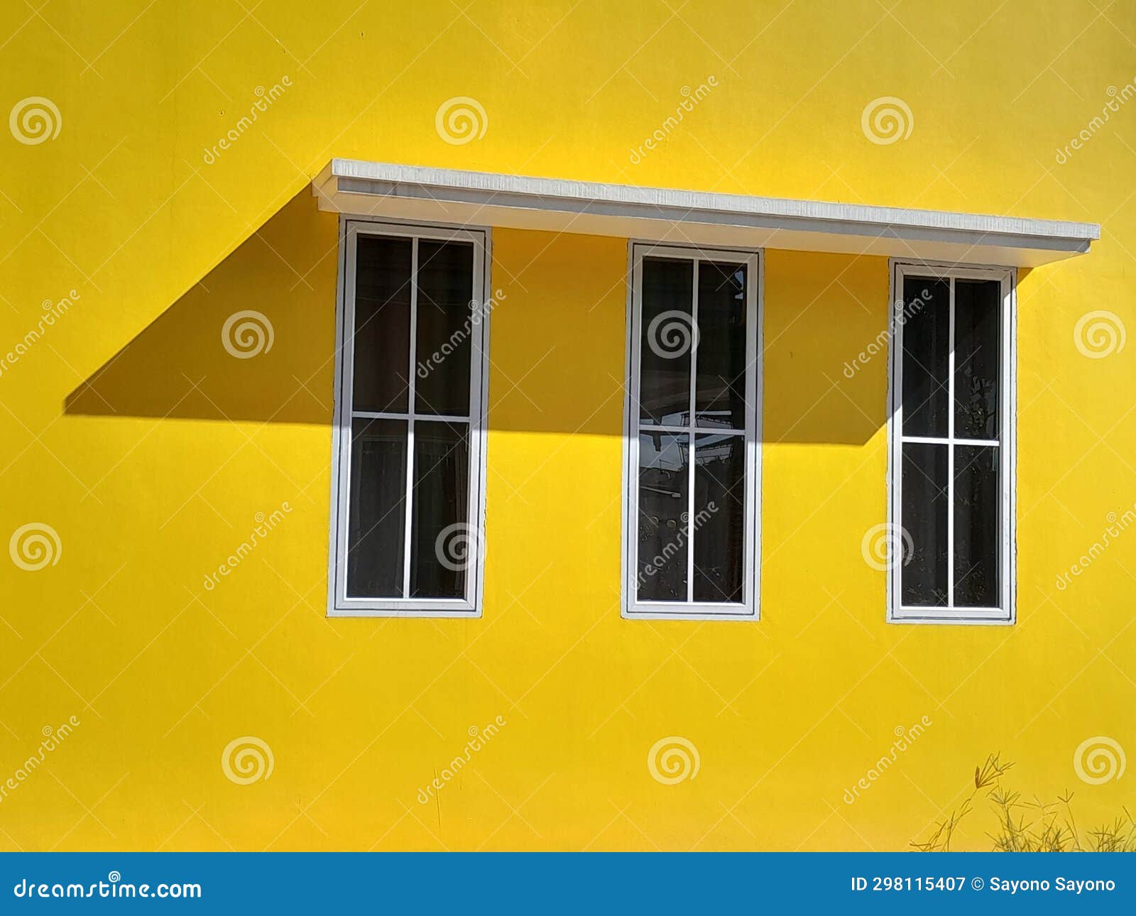 The Building is Painted Yellow with Three Windows. Stock Image - Image ...