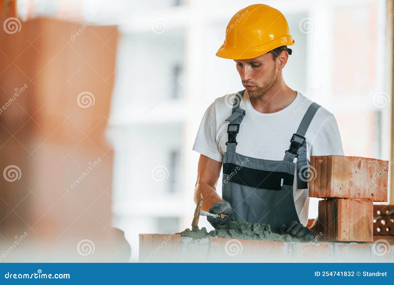 Building Process. Young Man Working in Uniform at Construction at ...