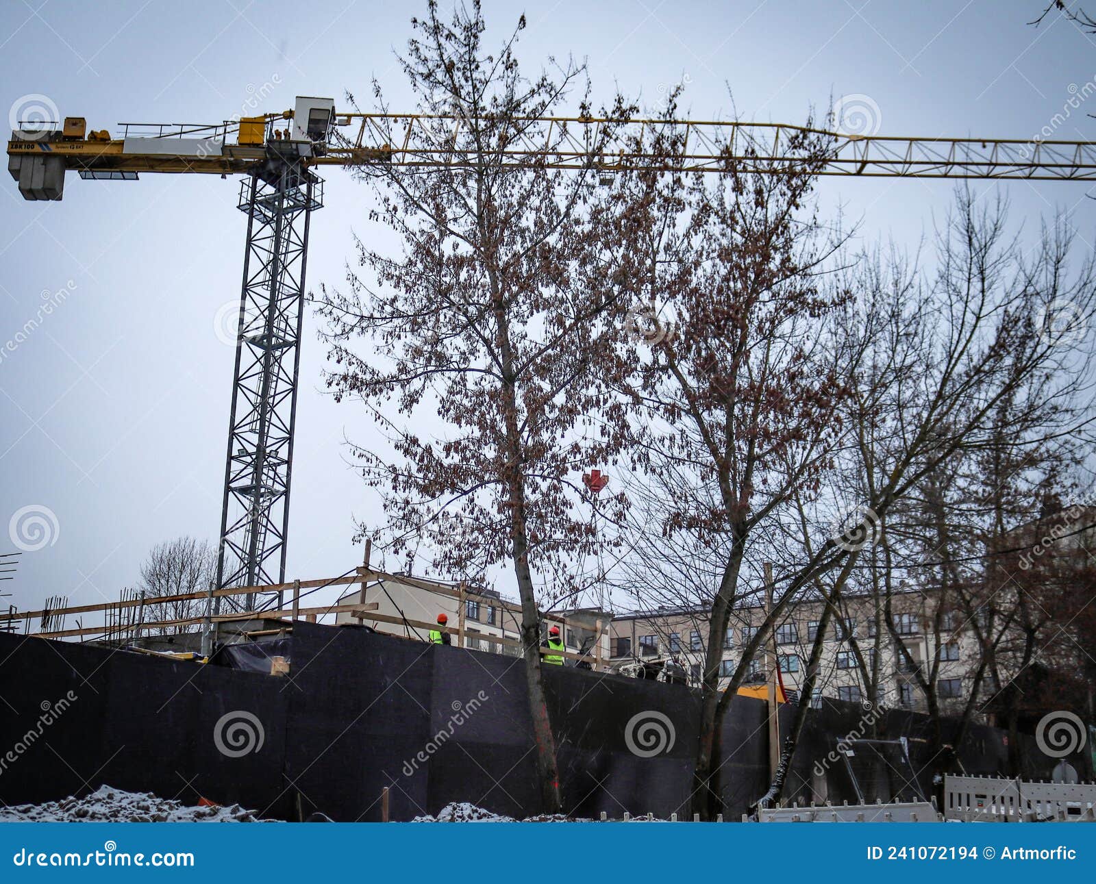 Building Site with Crane Behind a Fence Withleafless Trees Stock Photo ...