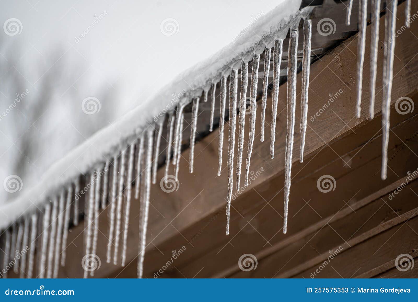 A Building with a Snowy Roof and Icicles on the Edge of the Roof Stock ...
