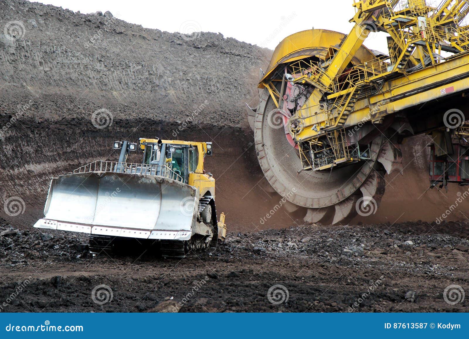 Bulldozer and Huge Mining Excavator Wheel in Brown Coal Mine Stock ...