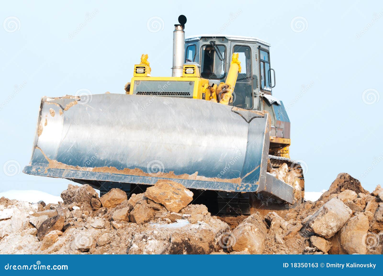 Bulldozer Or Loader At A Construction Site Shovels Mountain Soil Into A ...