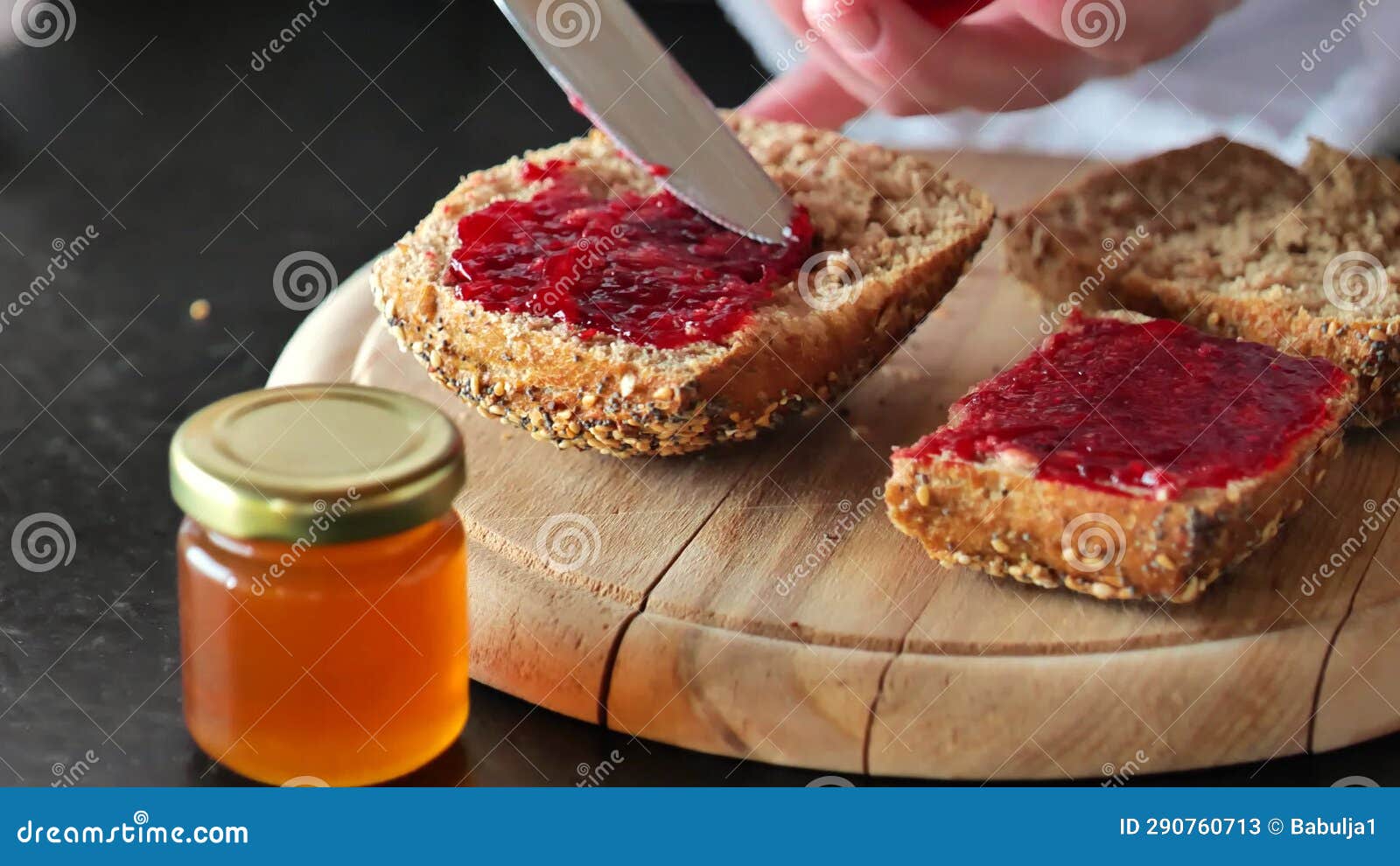 Bun with Raspberry Jam. Hands Spread Jam on a Whole Grain Bun Stock ...