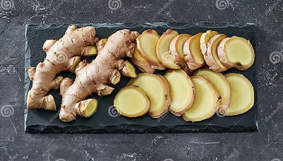 Bunch of Ginger Root and Ginger Slices are Displayed on a Dark Surface. Stock Image - Image of ...