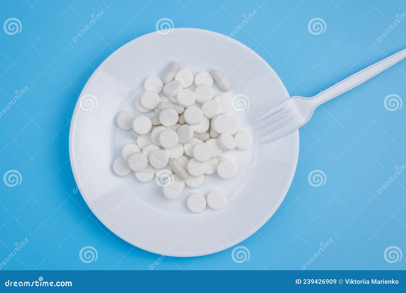 A Bunch of Medcin Tablets with a Fork on a Plate on a Blue Background ...