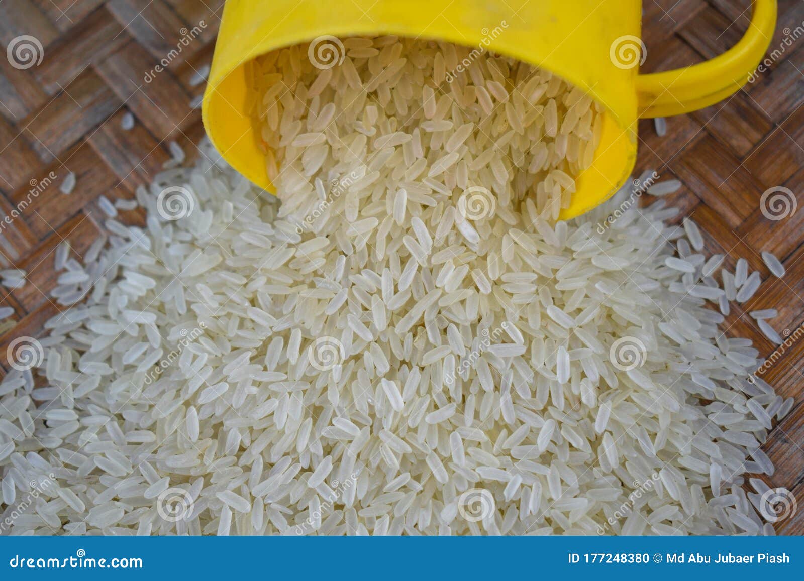 Bunch of Rice Grain Falling from a Yellow Cup on a Wooden Colored ...