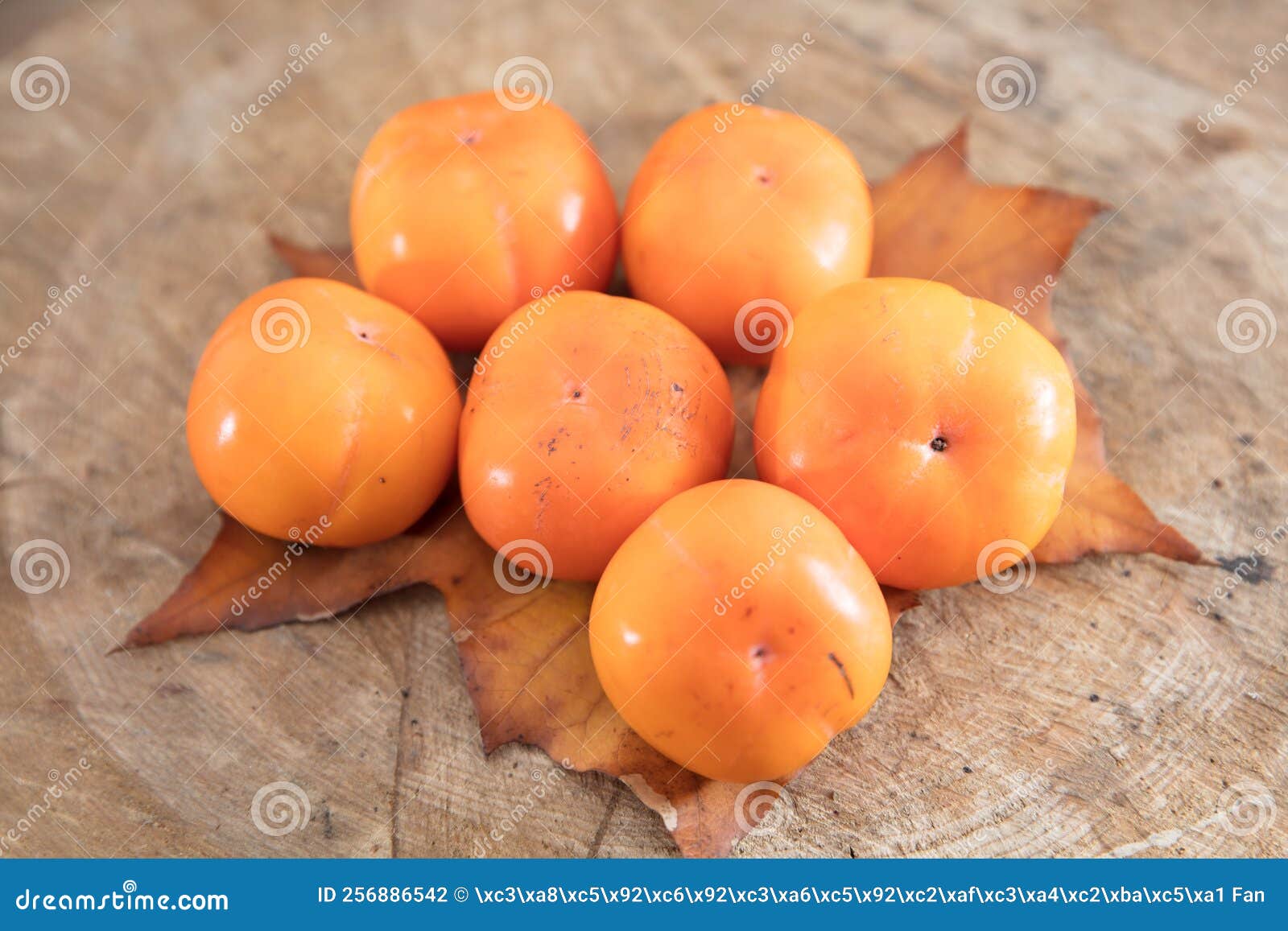 A Bunch of Ripe Crispy Persimmons on a Yellow Leaf Stock Photo - Image ...