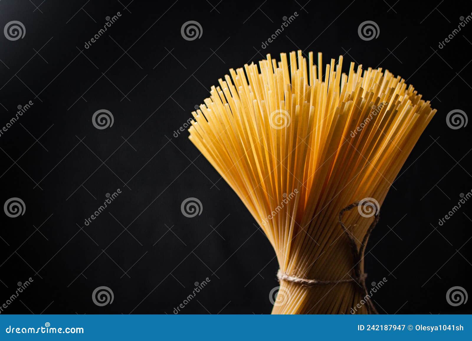 A Bundle of Spaghetti Dry Tied with a Rope Stands on the Table. Stock ...