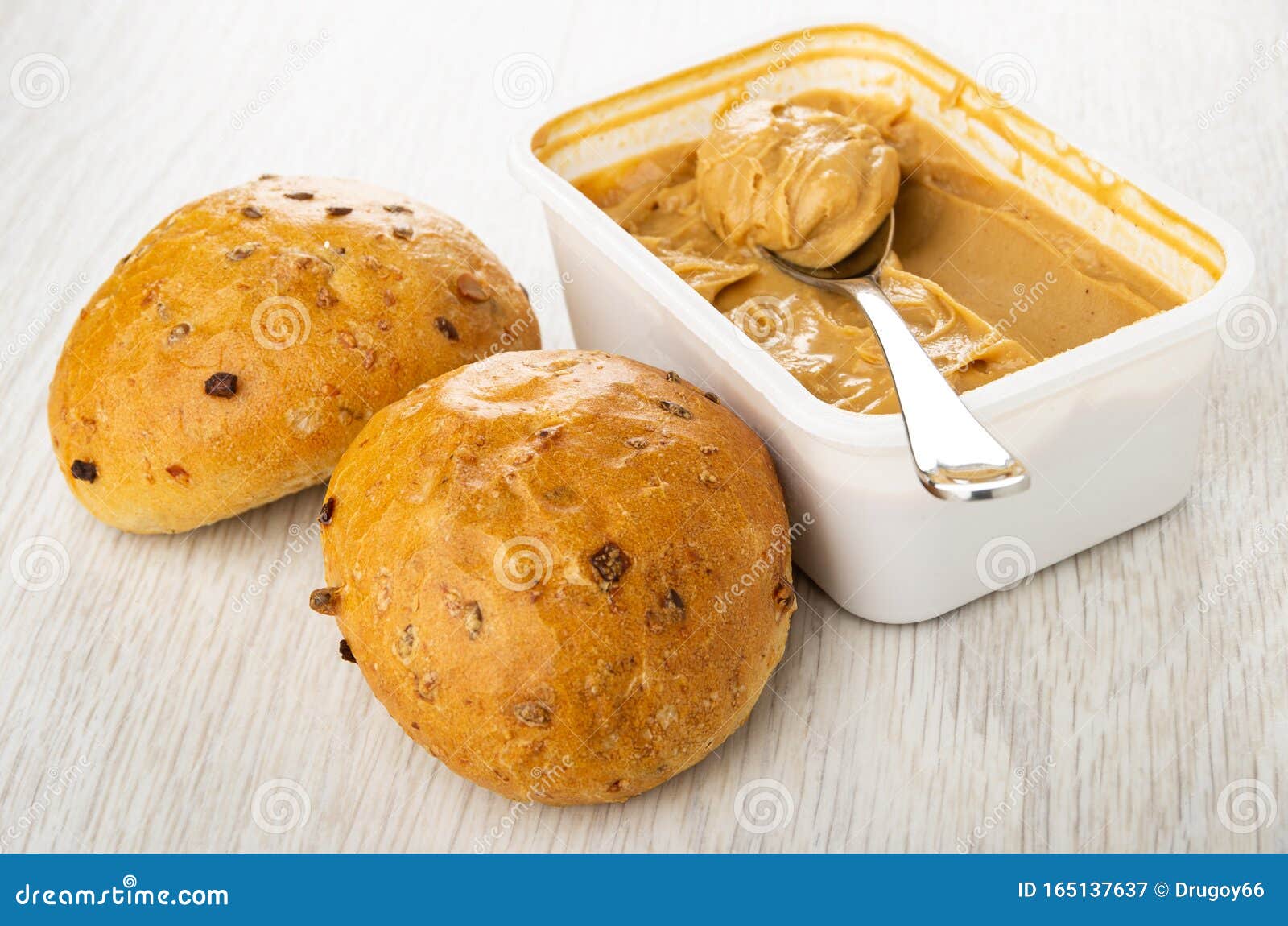 Buns, Container with Peanut Butter and Spoon on Wooden Table Stock ...