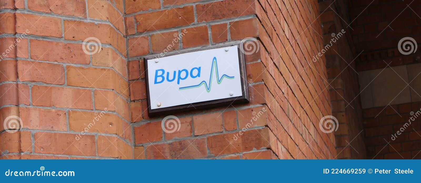 Bupa sign on brick wall editorial stock image. Image of selfisolation ...