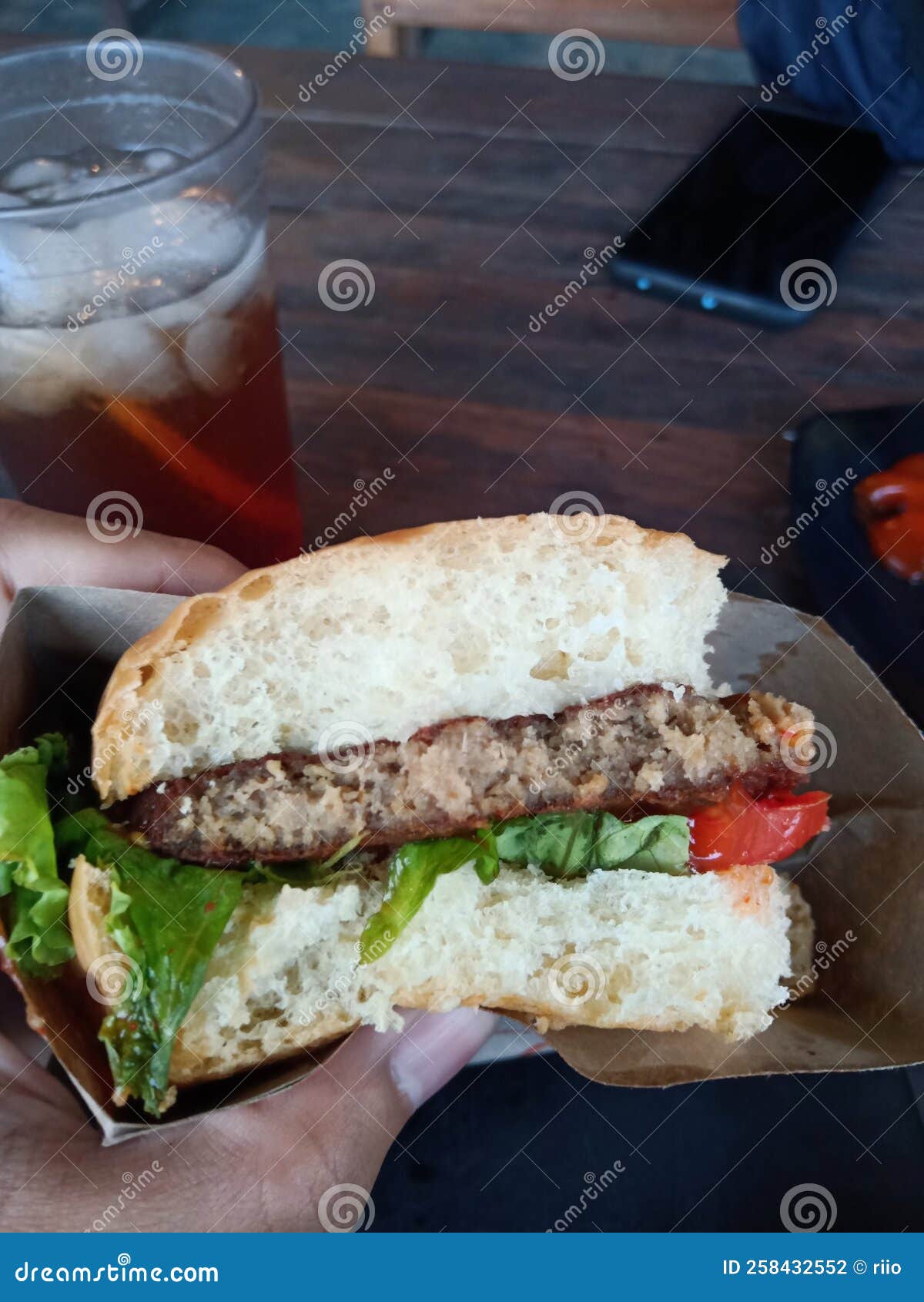 Burger bite and ice tea stock photo. Image of burger - 258432552