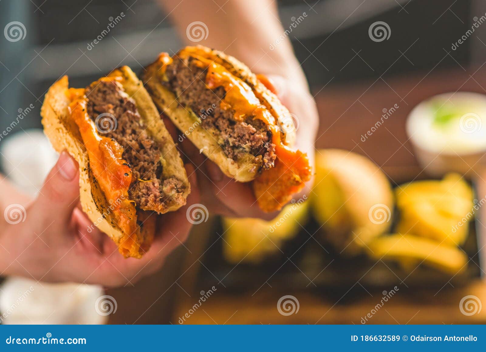 Burger Cut in Two Parts Held in Hands. Stock Image - Image of halves ...