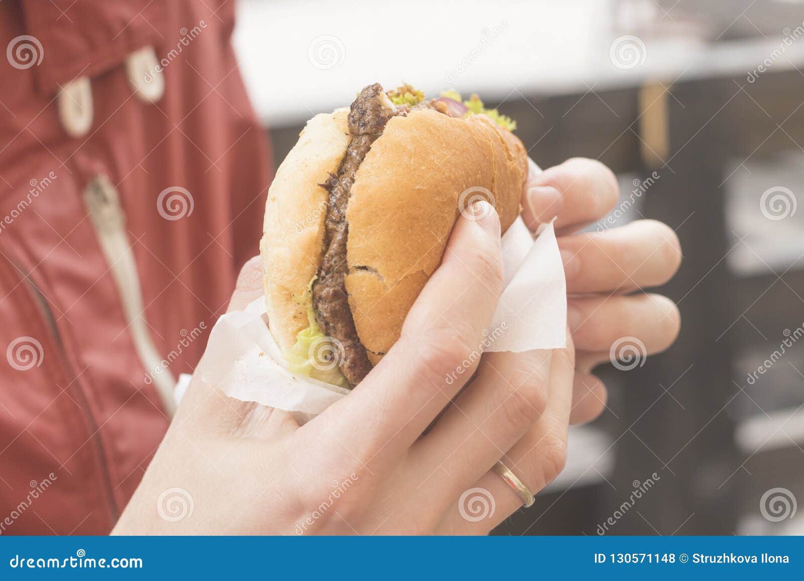 Burger in the hand. stock photo. Image of fastfood, bite - 130571148