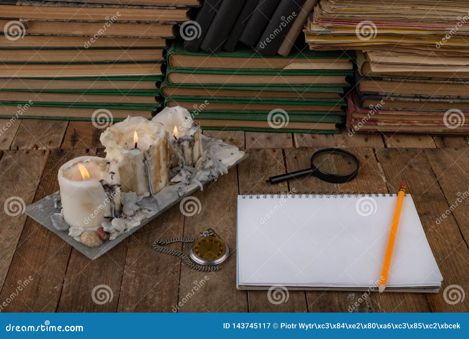 Burned Candle and a Notebook on an Old Wooden Table. Workplace of the ...