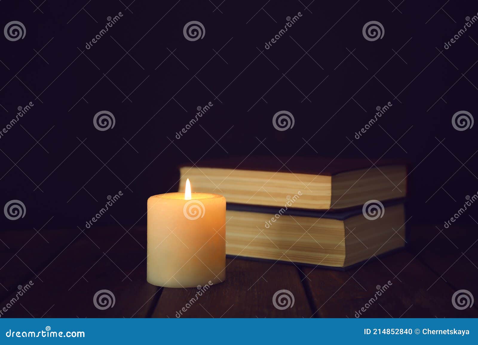Burning Candles and Stack of Books on Wooden Table in Darkness Stock ...