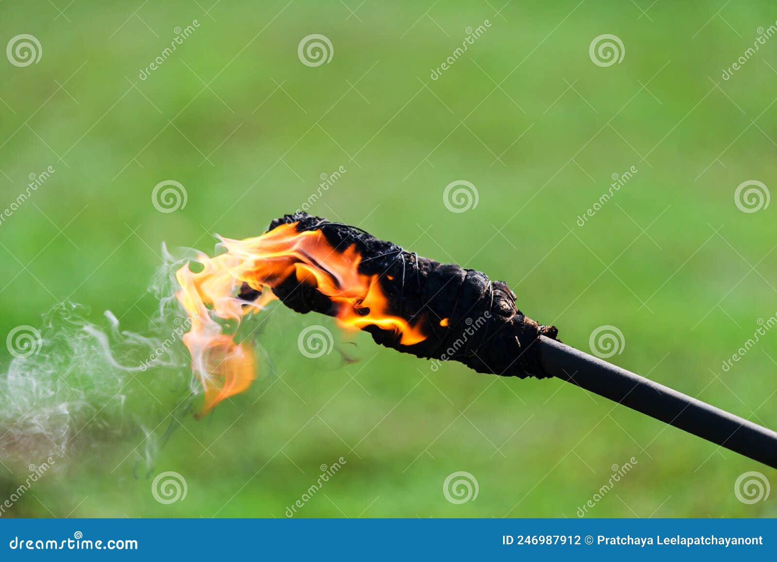 Burning Flame of a Torch on Green Grass Background before Nighttime ...