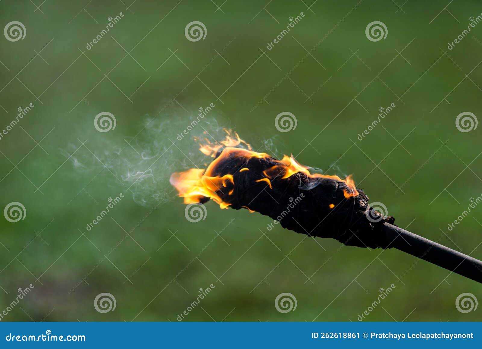 Burning Flame of a Torch on Green Grass Background before Nighttime ...