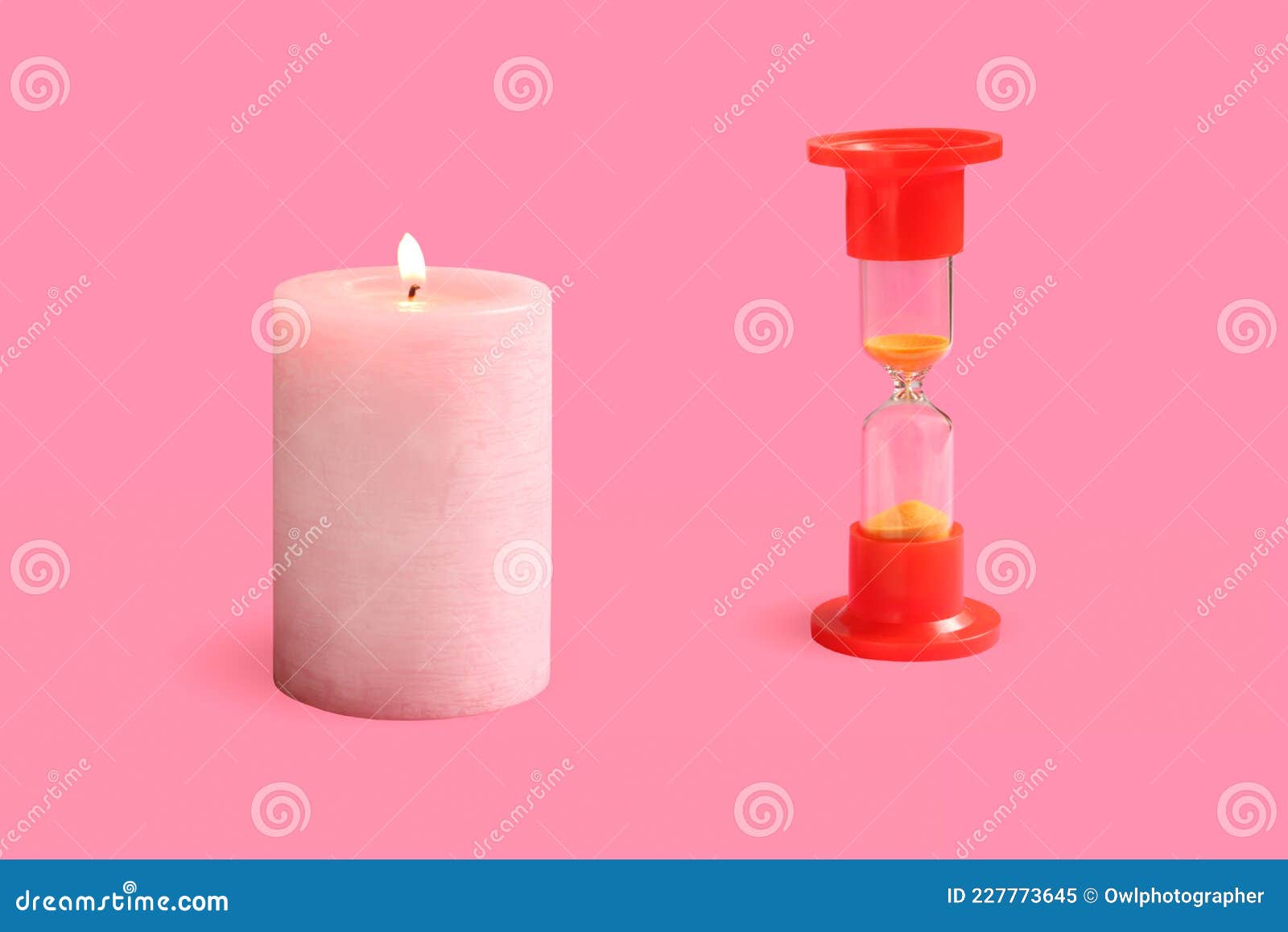 A Burning Pink Candle and an Hourglass on a Pink Background Stock Image ...