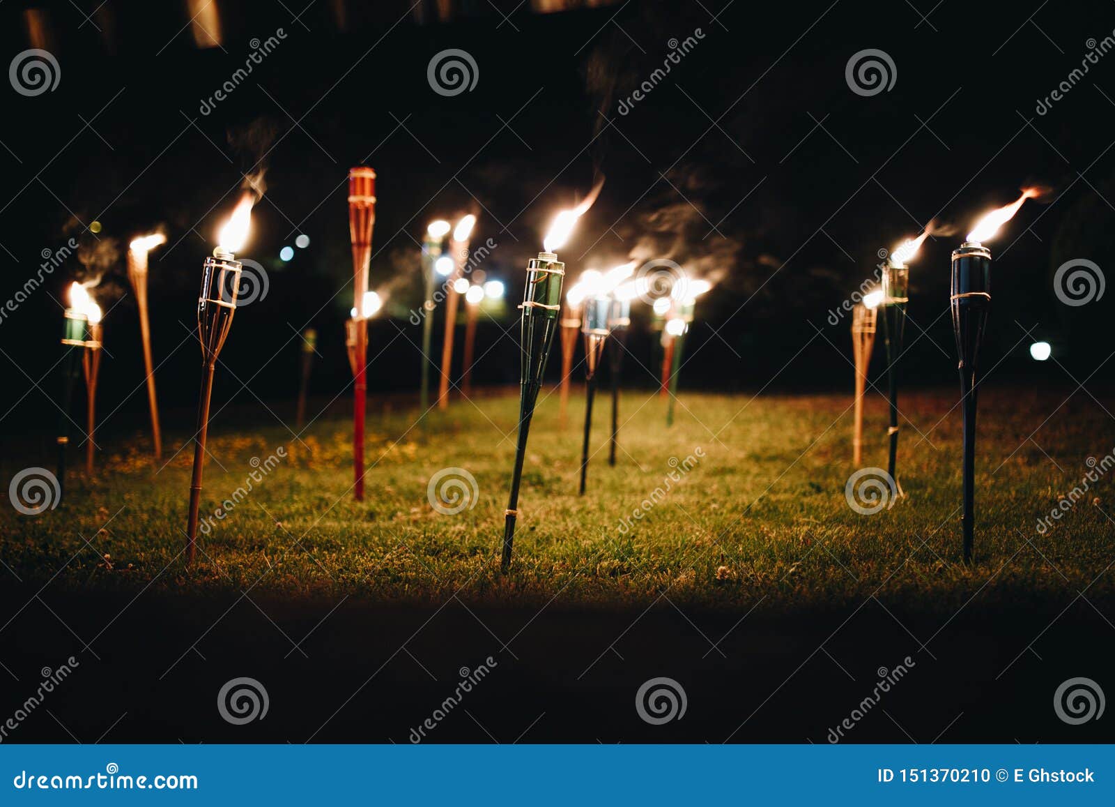 Burning Torches at Night in the Grass with Yellow Flames and Highlights ...