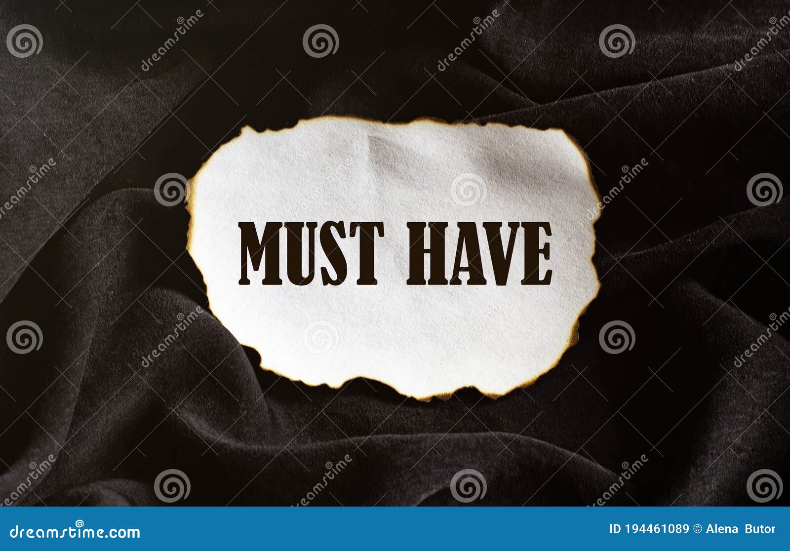 Burnt White Piece of Paper with Text Must Have on a Black Fabric ...