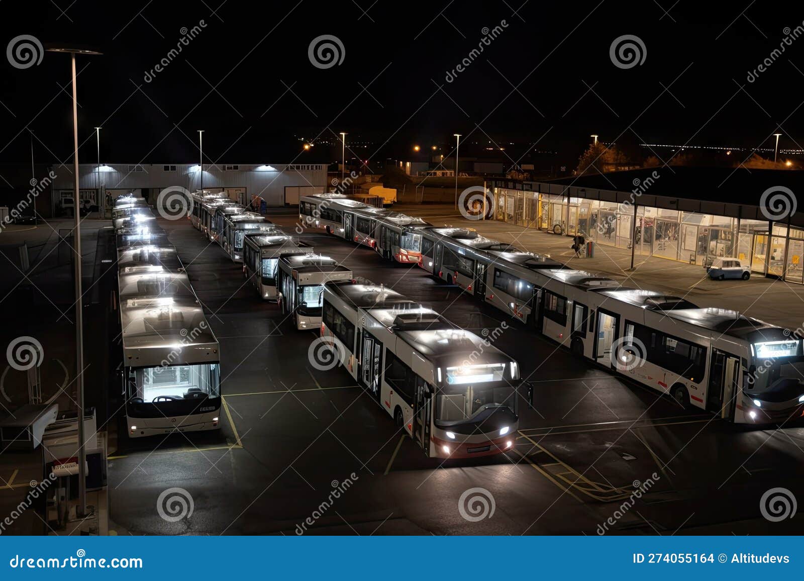 Bus Depot at Night, with Buses and Other Vehicles Illuminated by ...
