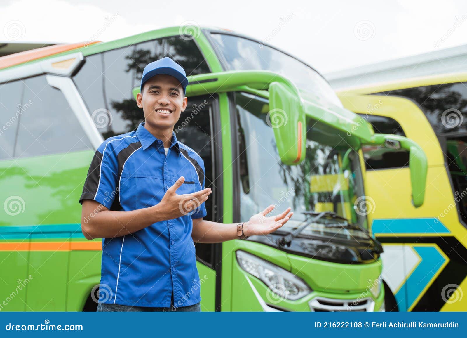 A Bus Driver in a Uniform and a Hat with a Hand Gesture Presents ...