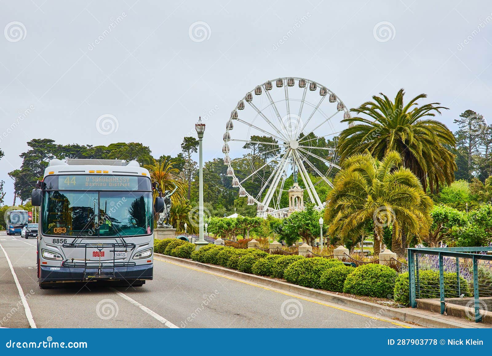 The 44 Bus Pulling Over on Road with SkyStar Wheel and Green Trees in ...