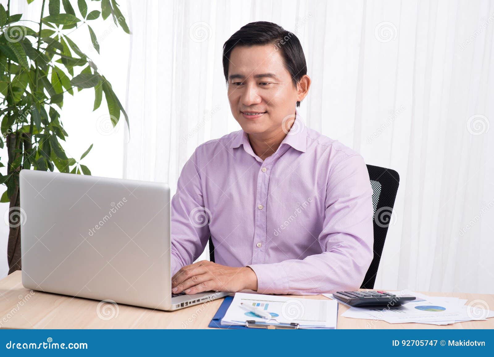Business Asian Man Sitting at His Desk Working on a Computer and Stock ...