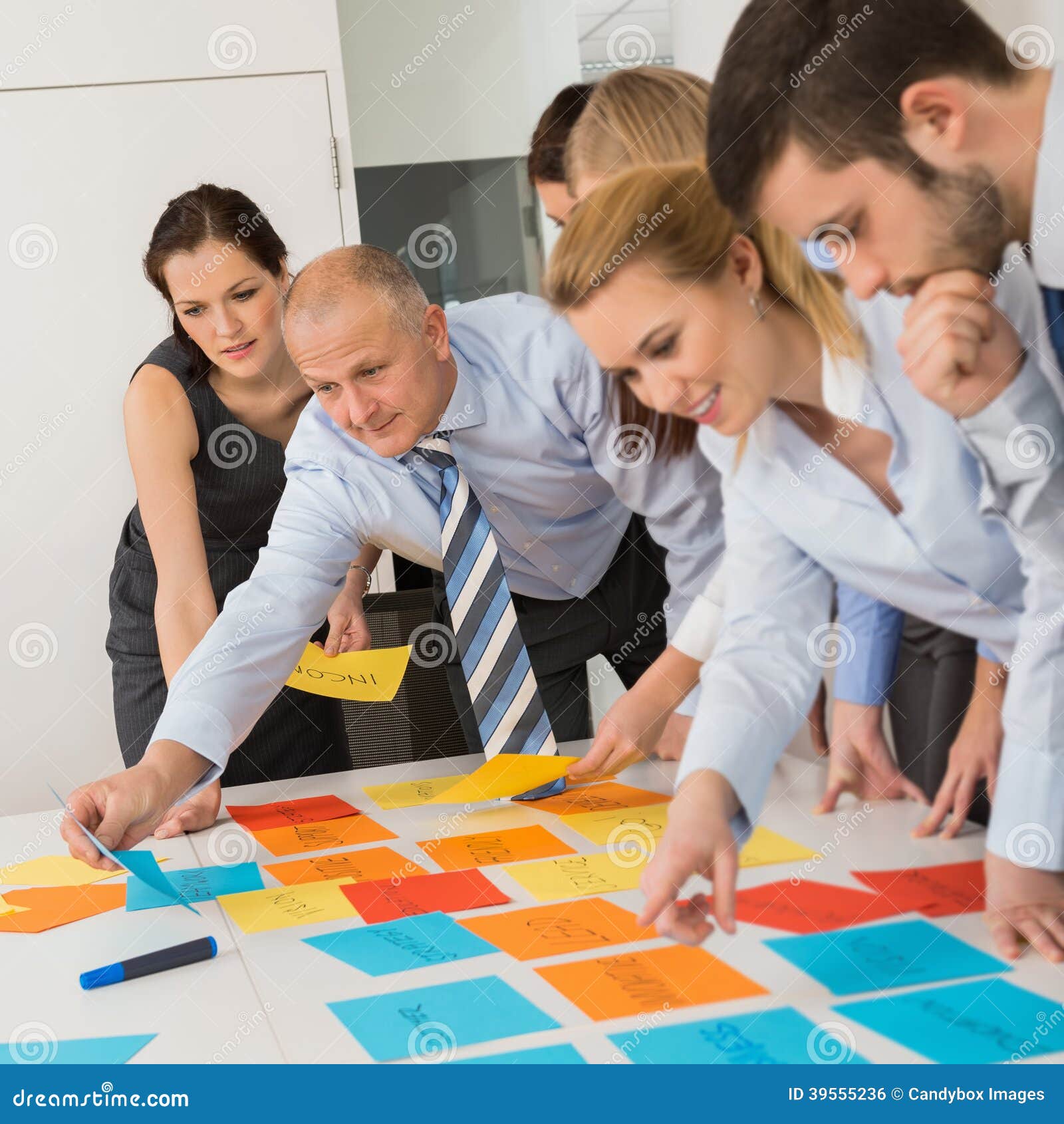 Business Colleagues Arranging Labels on Table Stock Photo - Image of ...