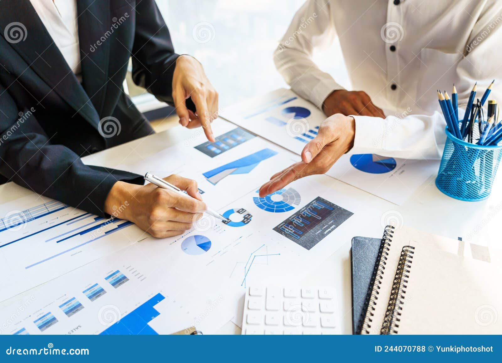 Business Colleagues Discussing Graph Paperwork Ideas at Desk Stock ...