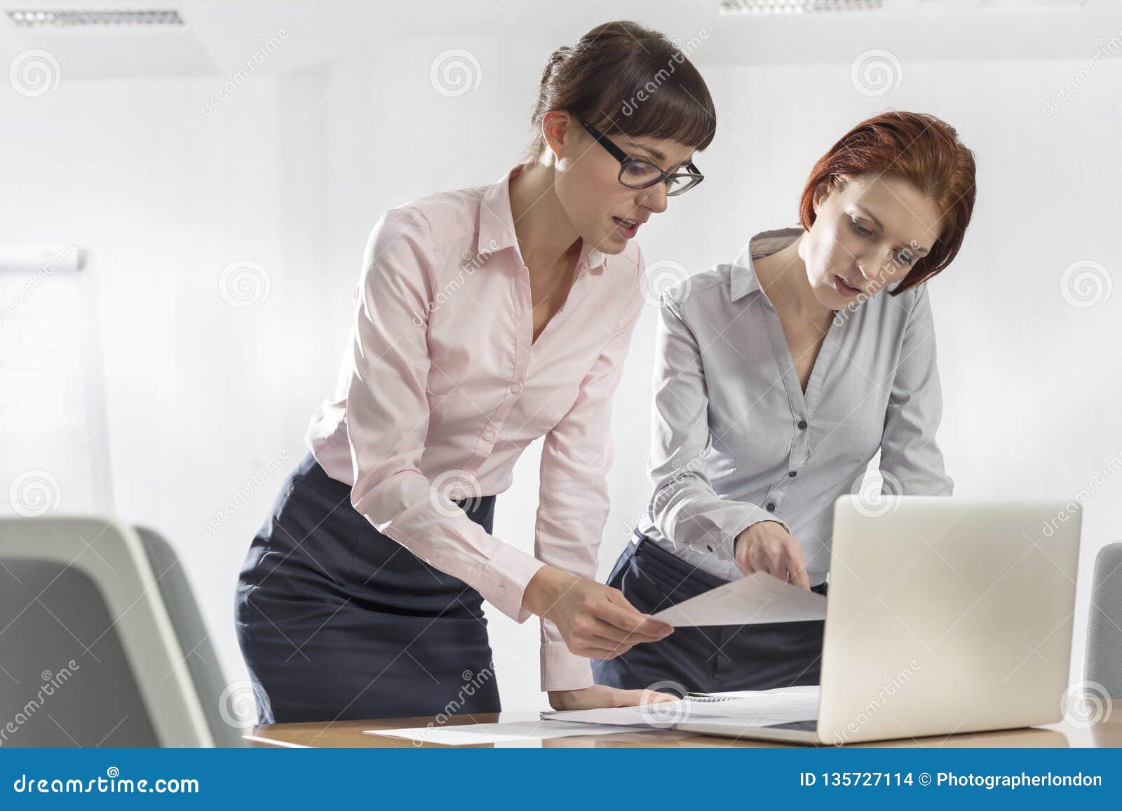 Business Colleagues Discussing Over Documents at Desk in Office Stock ...