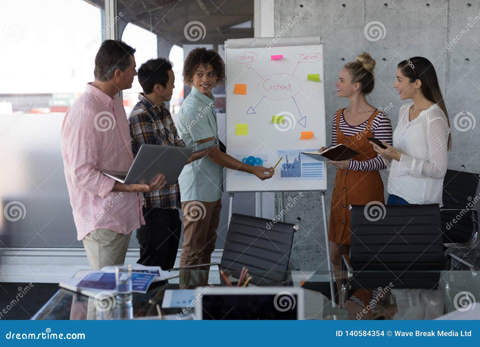 Business Colleagues Discussing Over Flip Chart in Office Stock Photo ...