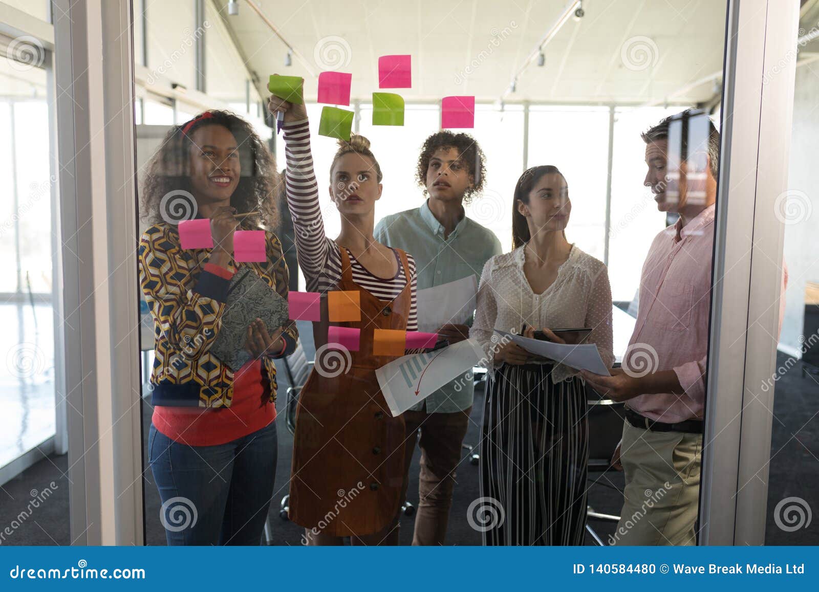 Business Colleagues Discussing Over Sticky Notes in Office Stock Photo ...