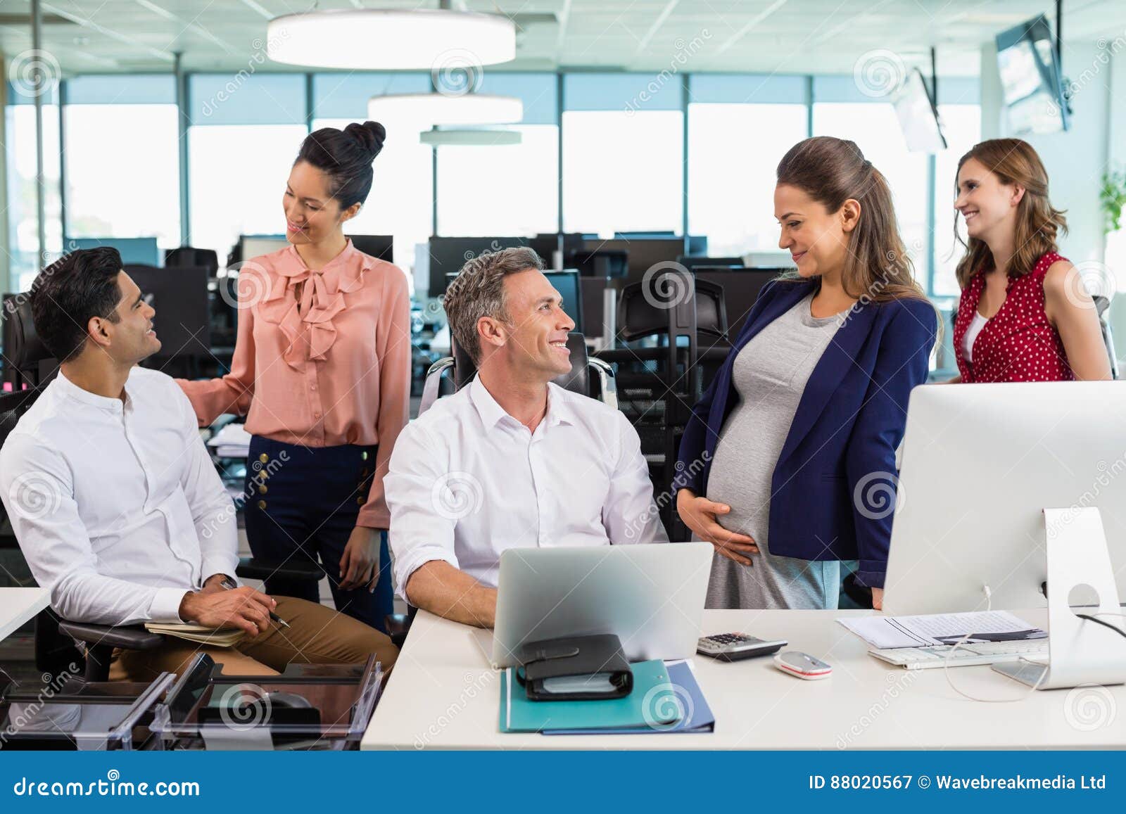 Business Colleagues Interacting with Each Other at Desk in Office Stock ...
