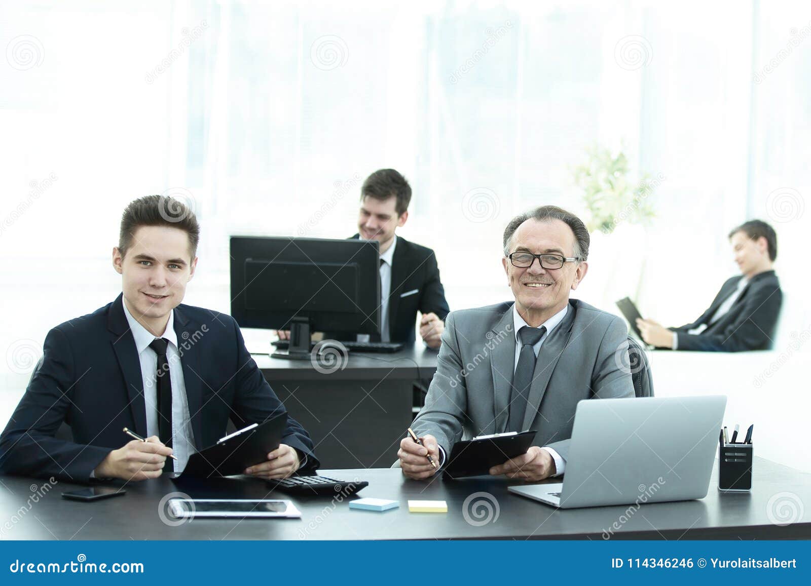 Business Colleagues Sitting at a Desk in the Office. Stock Photo ... Business Colleagues Sitting at a Desk in the Office. Stock Photo ...