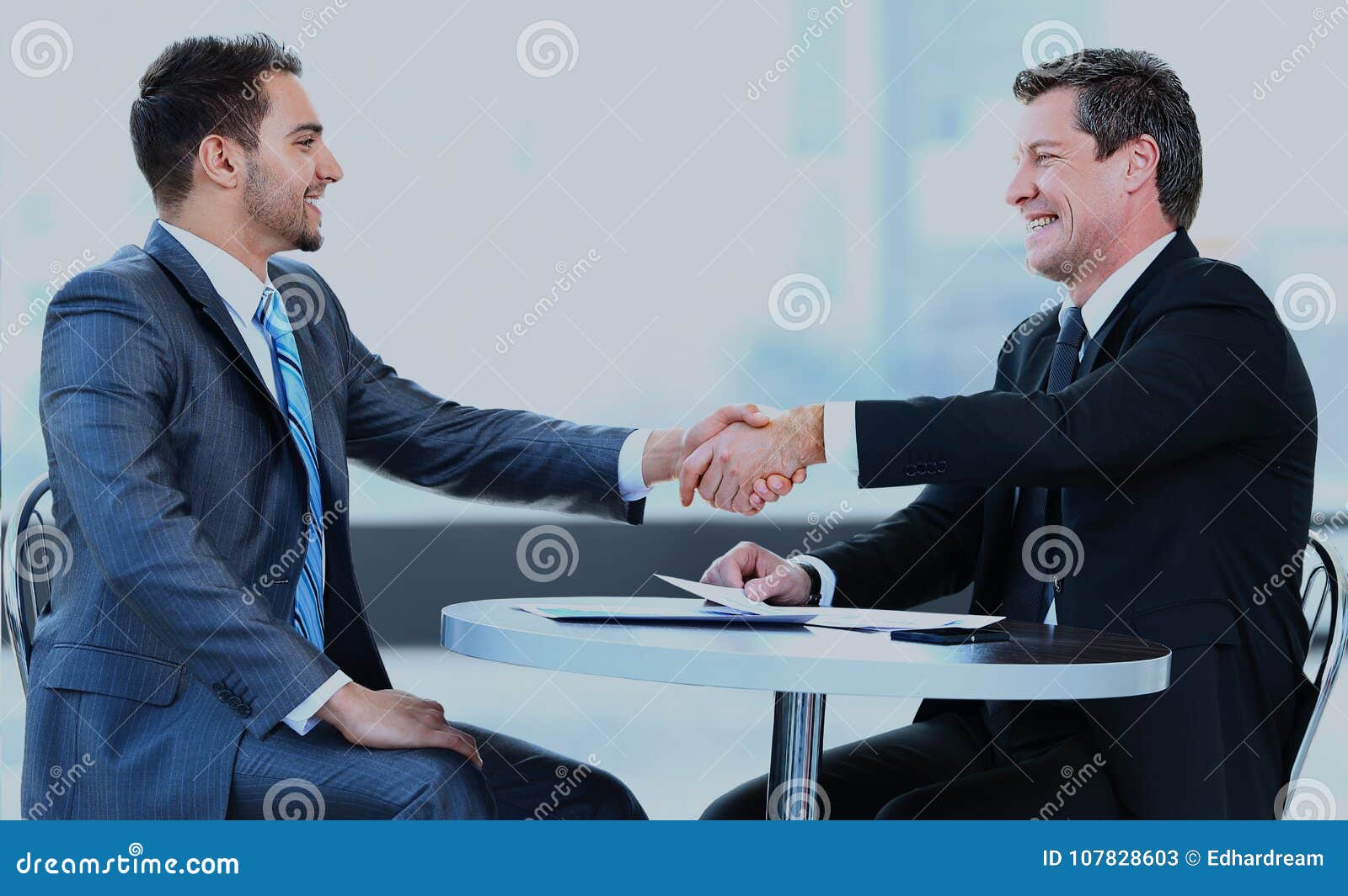 Business Colleagues Sitting at a Table during a Meeting with Two Male ... Business Colleagues Sitting at a Table during a Meeting with Two Male ...