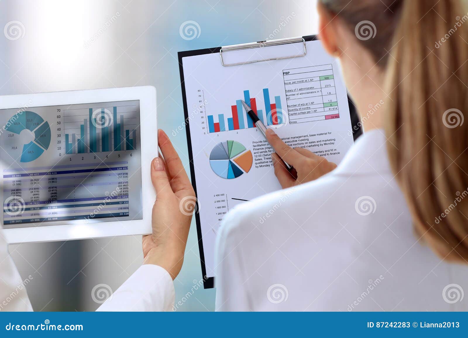 Business Colleagues Working and Analyzing Financial Figures on a Graphs ...