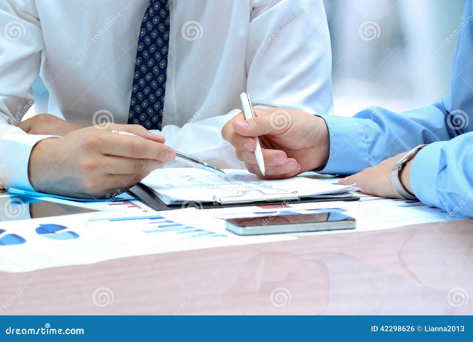 Business Colleagues Working and Analyzing Financial Figures on a Graphs ...