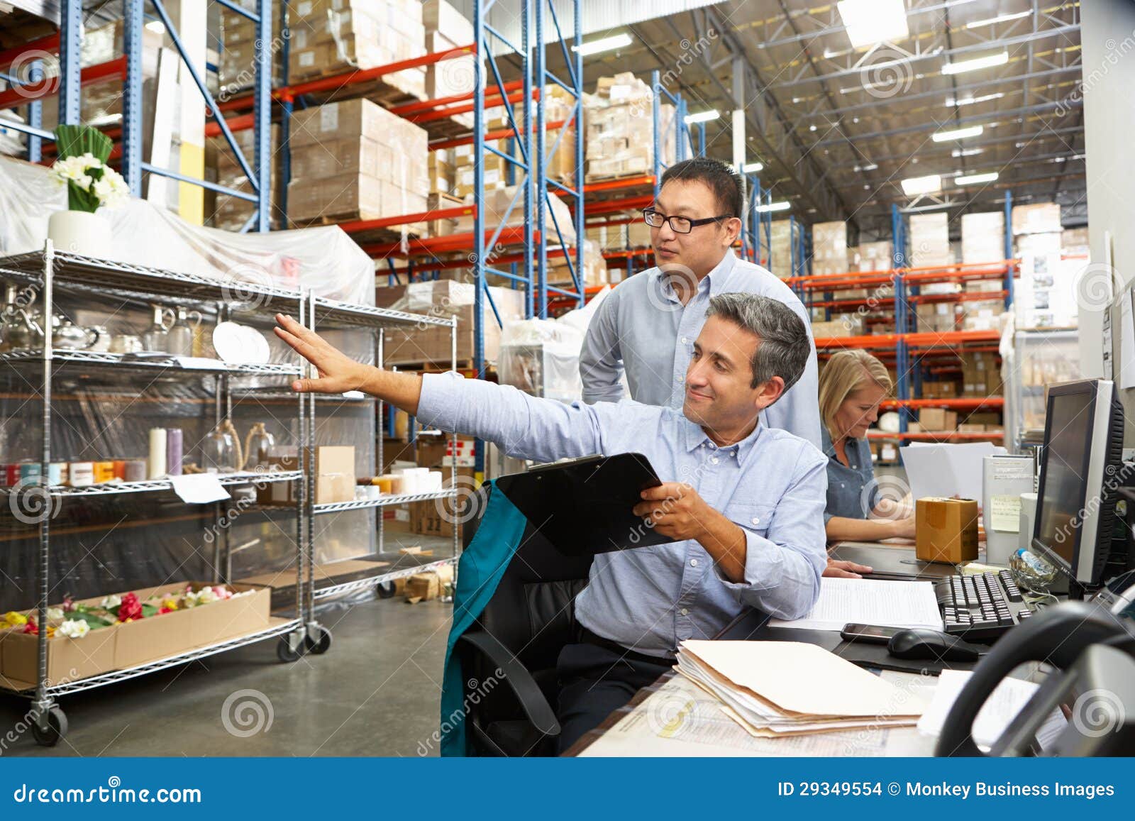 Business Colleagues Working at Desk in Warehouse Stock Photo - Image of ...