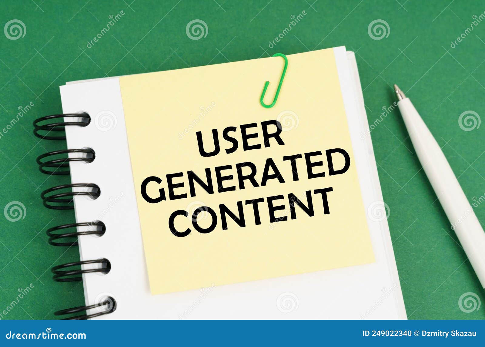 On a Green Surface, a Pen, a Notepad with Stickers and the Inscription ...