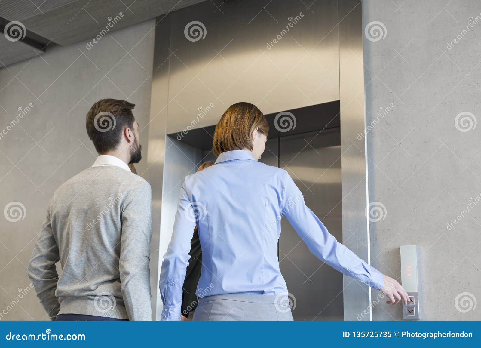 Business Colleagues Waiting for Elevator at Corporate Office Stock ...