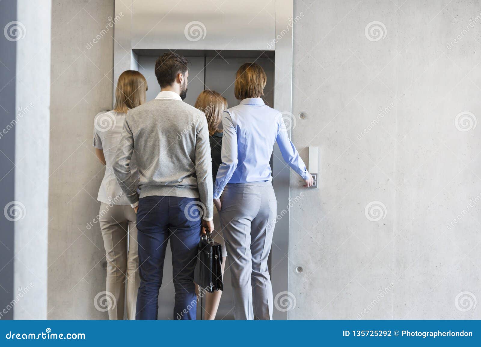 Rear View of Business People Waiting for Elevator at Office Stock Photo ...