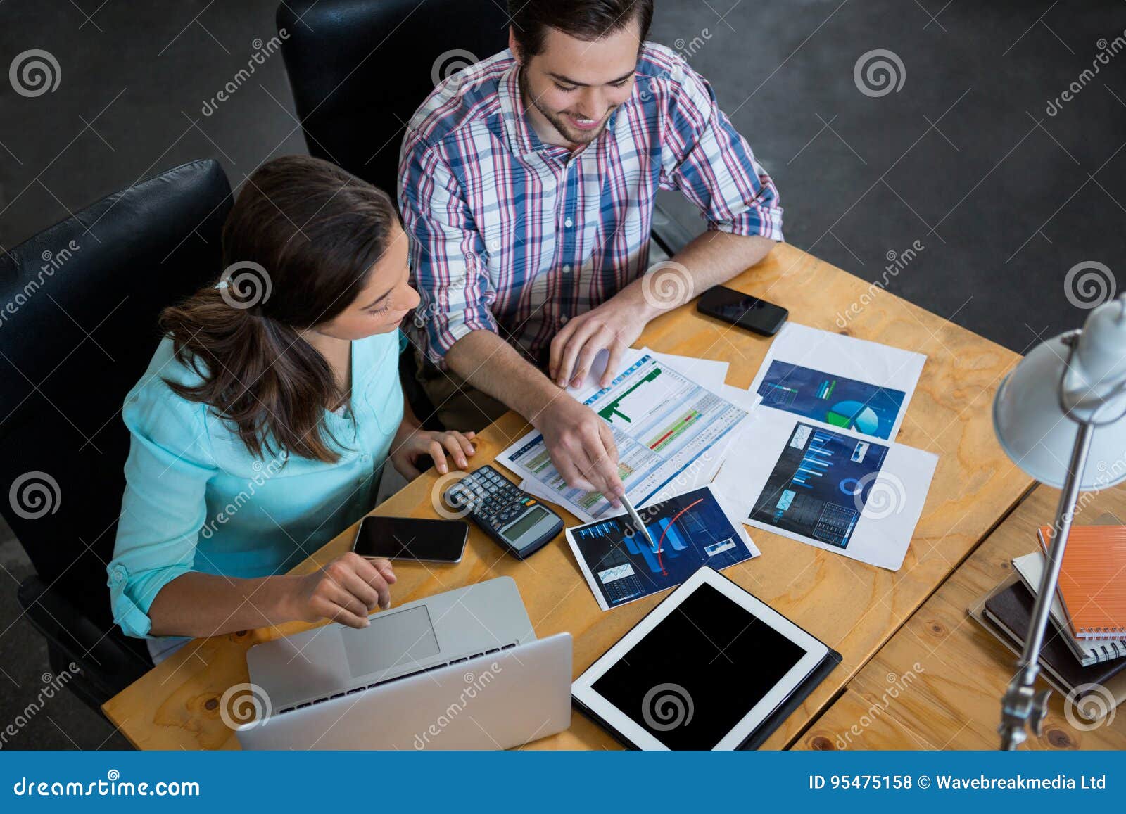 Business Executives Discussing Charts and Graphs on Desk Stock Photo ...