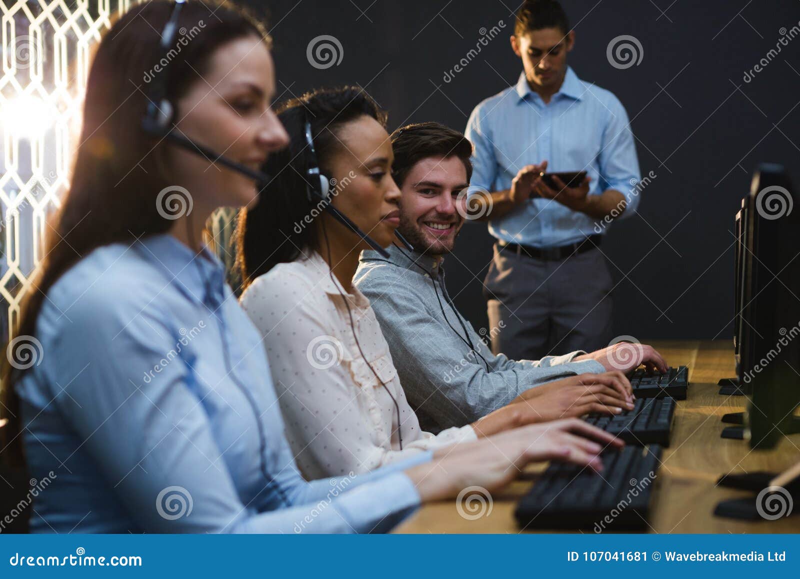 Business Executives with Headsets Using Computers at Desk Stock Image ...